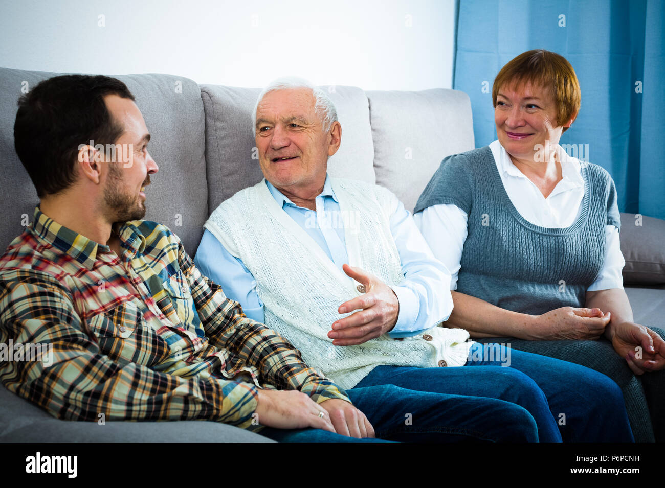 Grandfather and grandmother warmly conversation with grandson at home ...