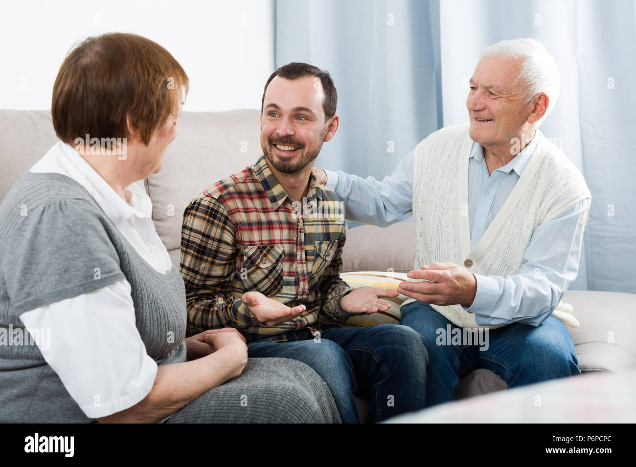Grandfather and grandmother warmly conversation with grandson at home ...