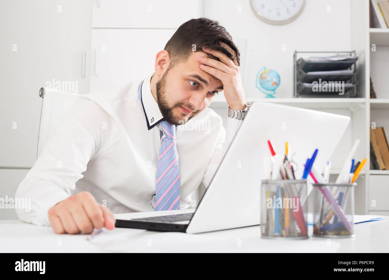 Stressed man worker facing challenge in project in office Stock Photo ...