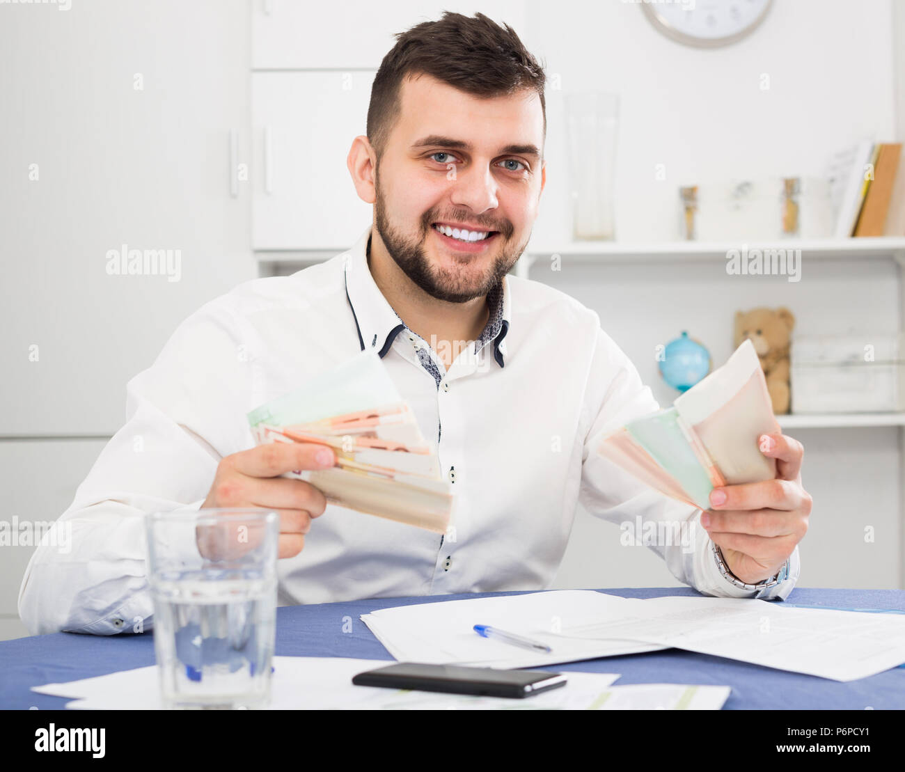 Positive male worker earning money effectively online at home Stock ...