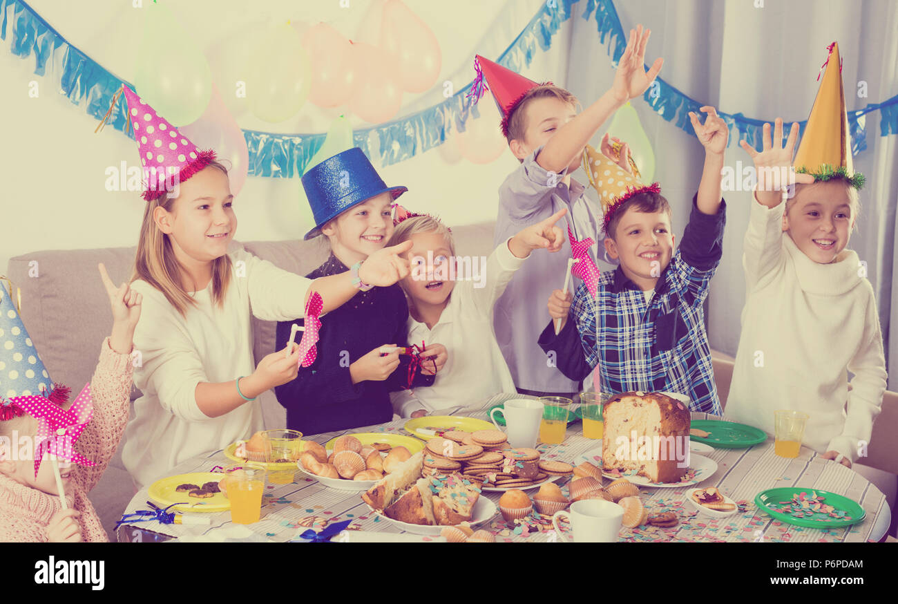 Cheerful group of children having fun during friend’s birthday party ...