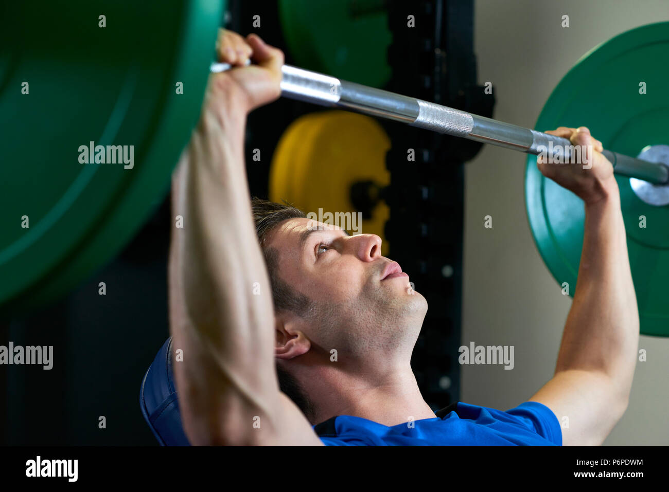 Man In Gym Lifting Heavy Weights On Bar Stock Photo - Alamy