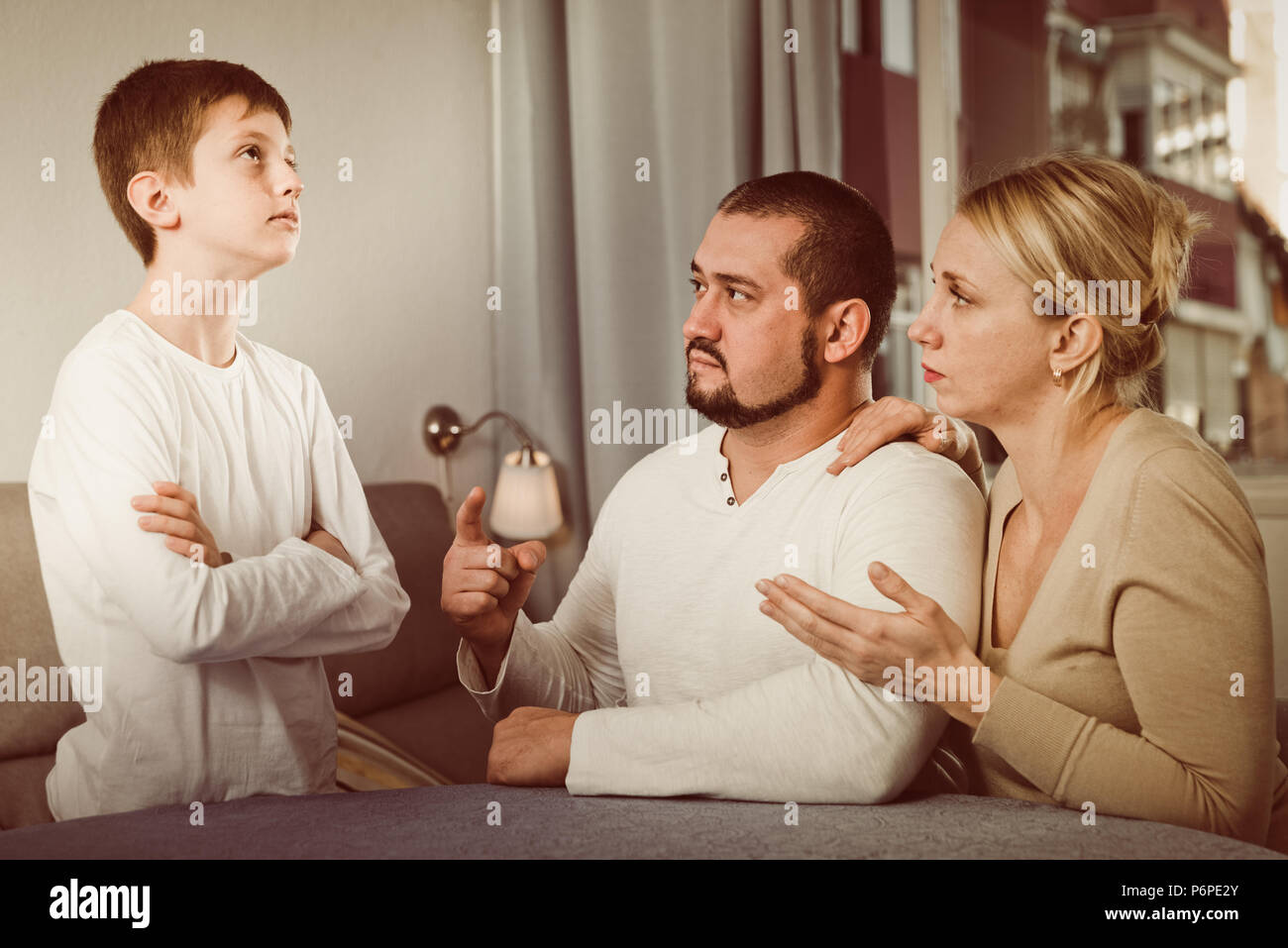 Upset parents berating their son at home Stock Photo - Alamy