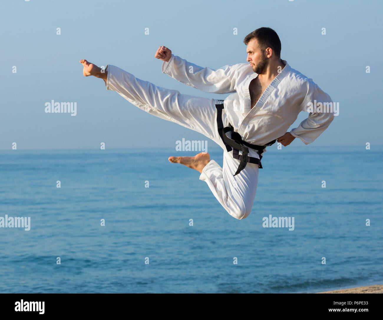 young man practicing karate positions at ocean quay Stock Photo - Alamy