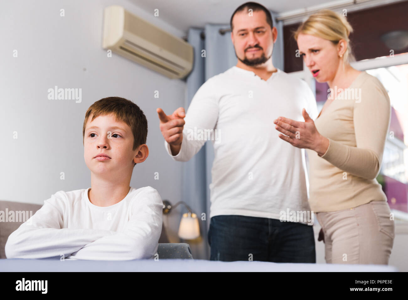 Portrait of upset boy scolded by parents at home Stock Photo - Alamy
