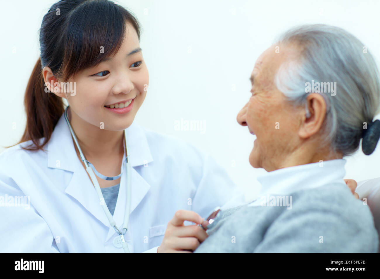 one young asian female doctor doing health check to senior Chinese ...