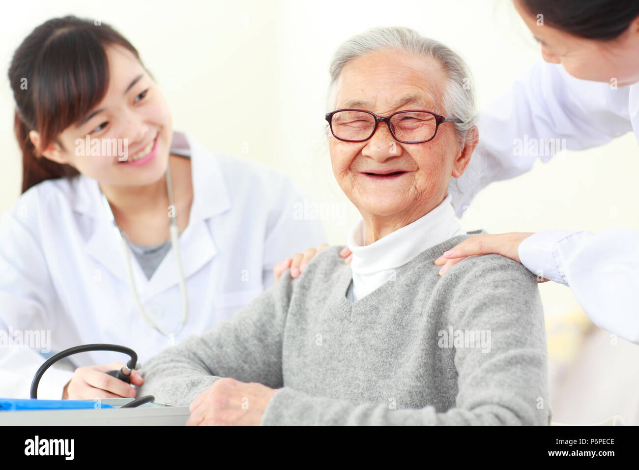 one young asian female doctor doing health check to senior Chinese ...