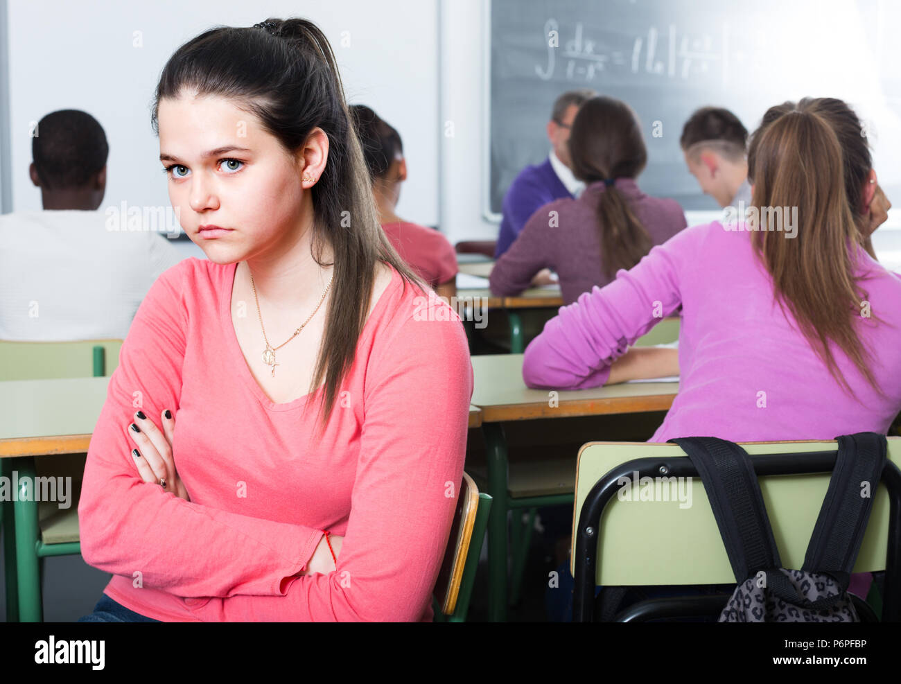 lonely american school pupil sitting away from classmates and feeling ...