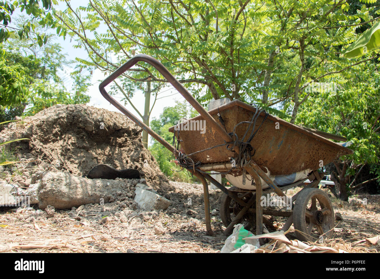A soil with a hoe in old wheelbarrow in a tropical garden Stock Photo ...