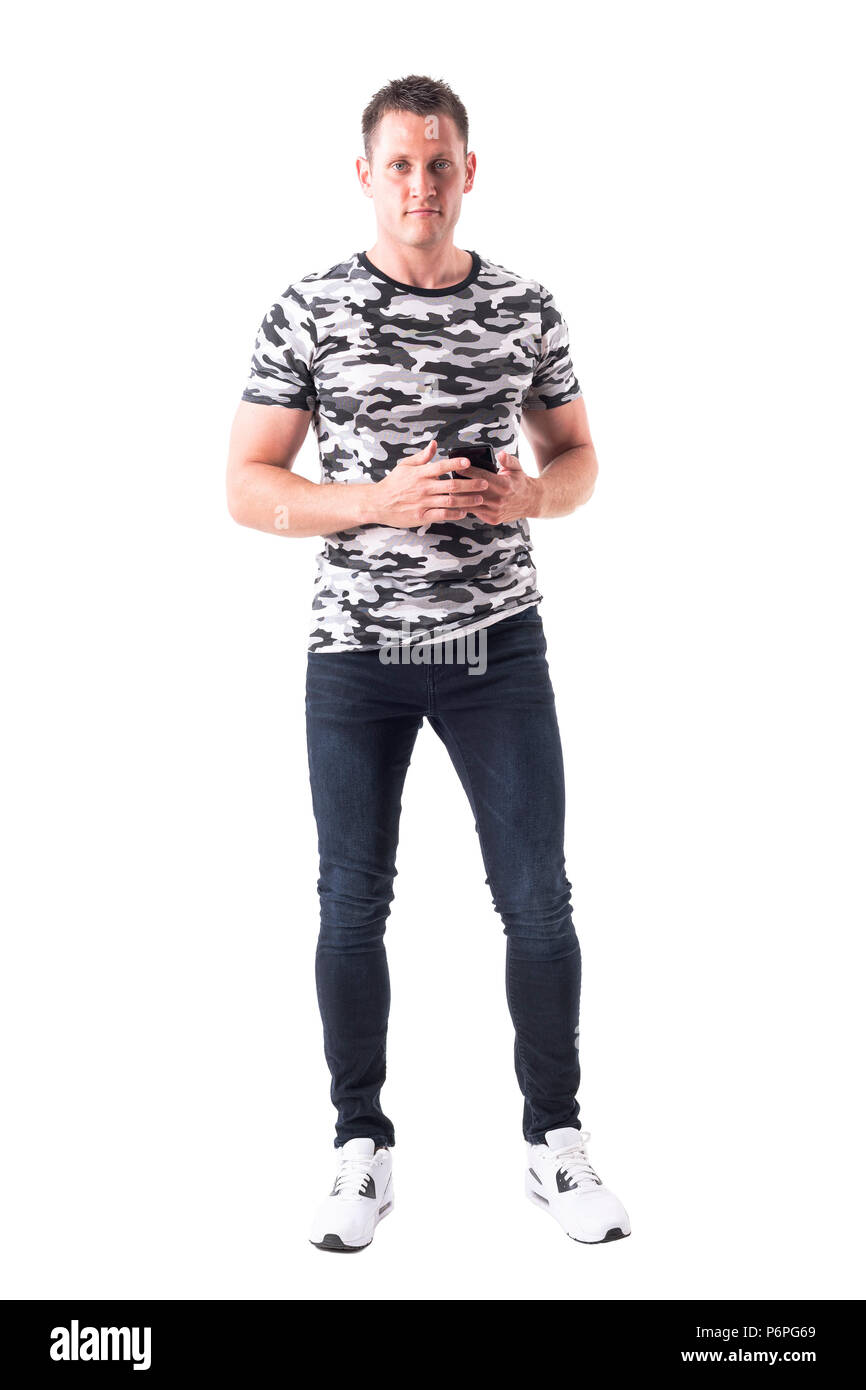Handsome muscular stylish man in camo shirt holding mobile phone and ...