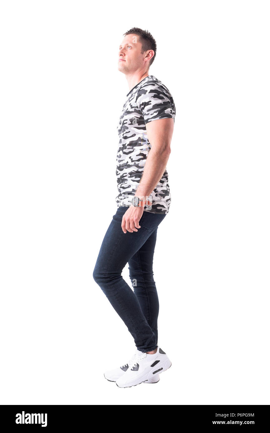 Handsome fit man in army pattern t-shirt walking and looking up. Side ...