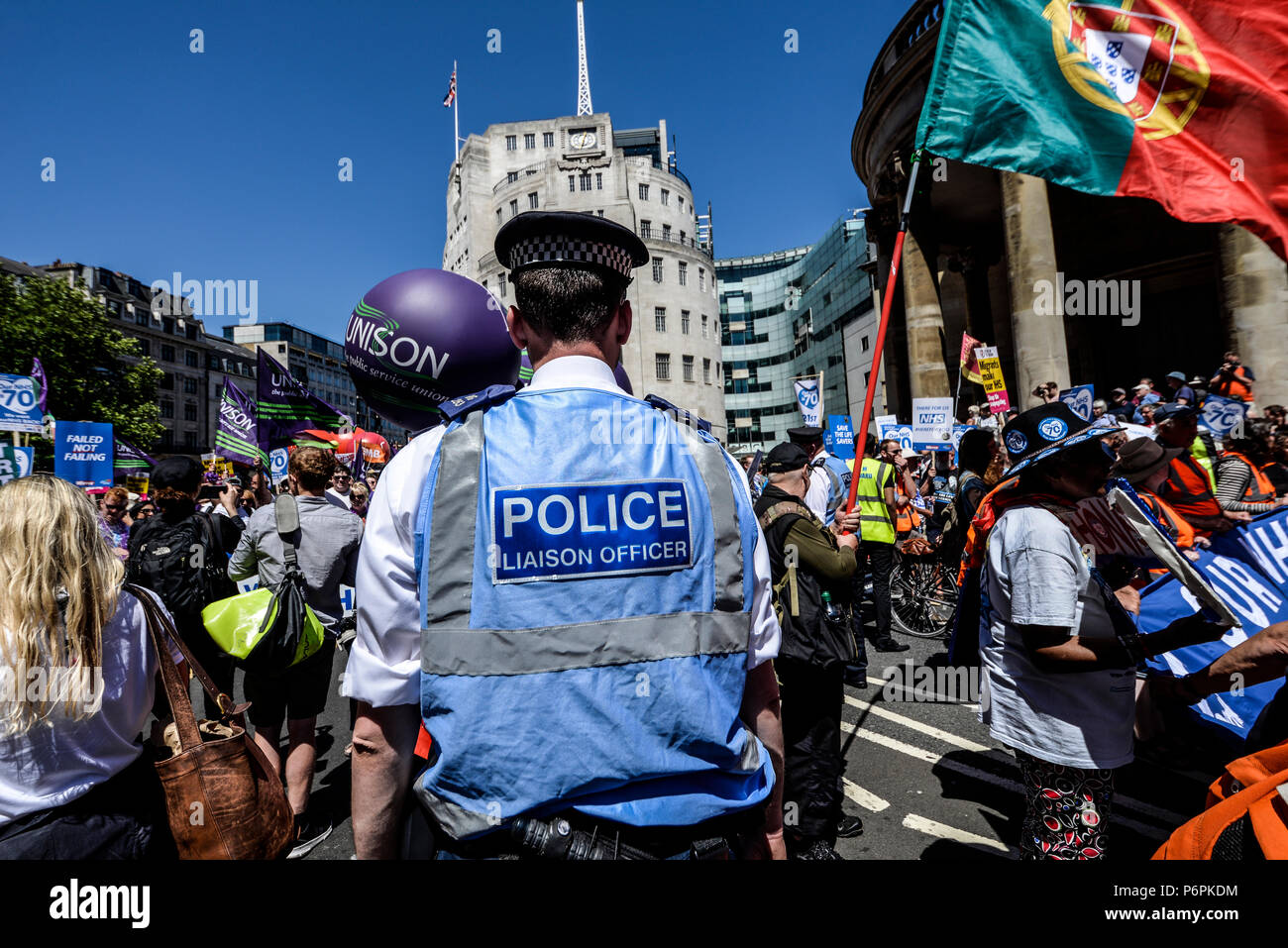 Police liaison officer in London, UK, with crowds of demonstrators ...