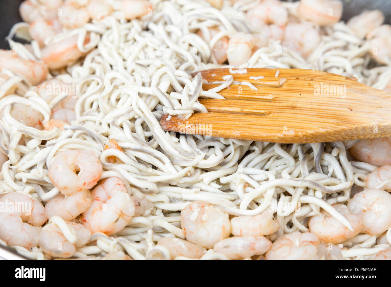 preparing the guides with shrimp in the pan and stir with wooden fork ...
