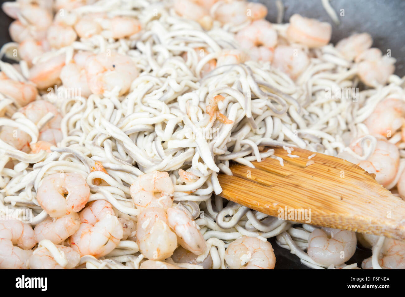 preparing the guides with shrimp in the pan and stir with wooden fork ...