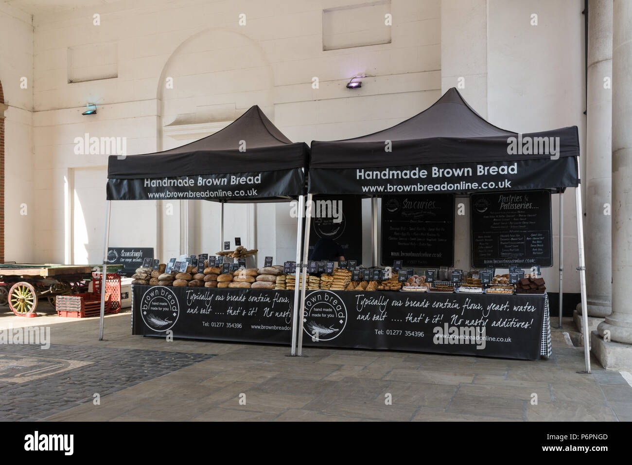 Market stall selling handmade brown bread under Tunsgate Arch off the High Street in Guildford ...