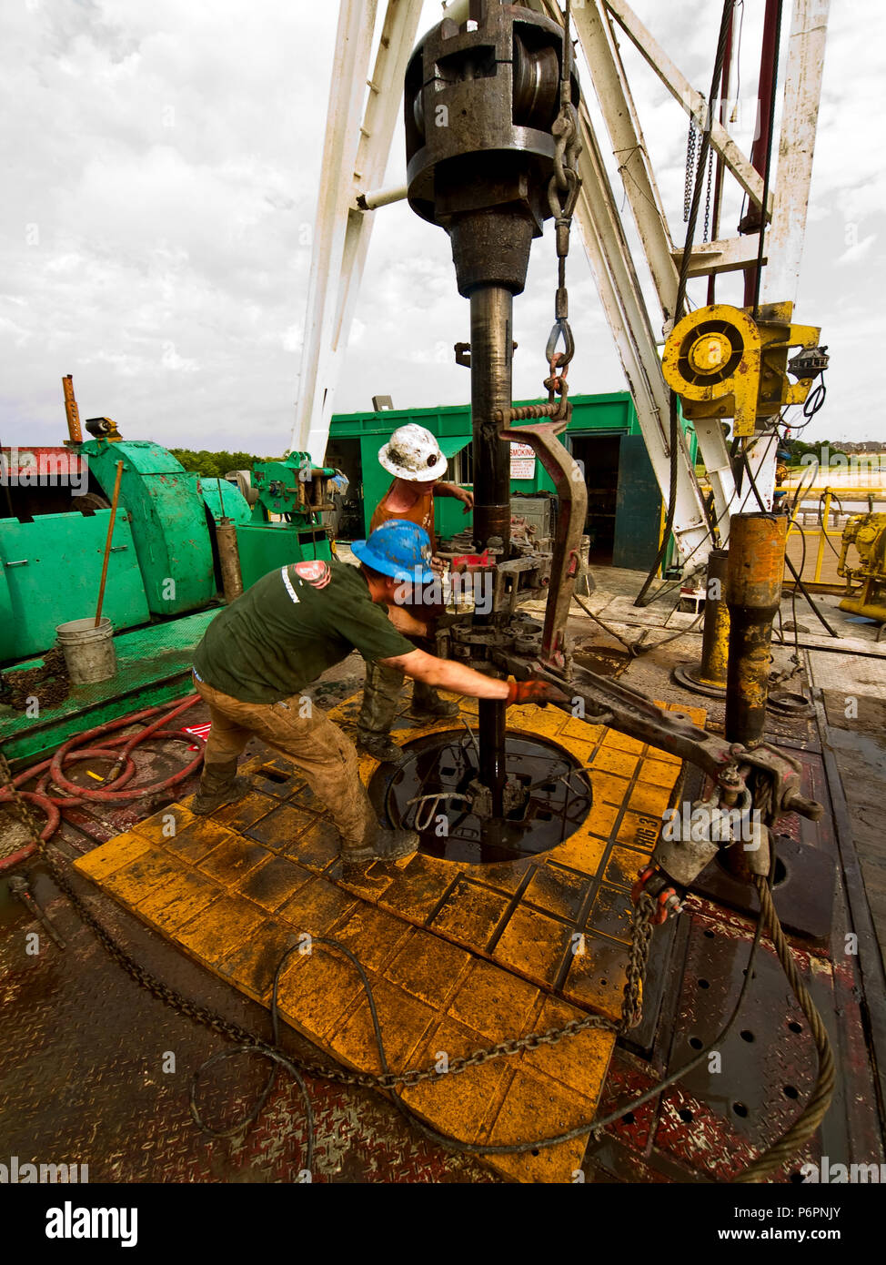 Adding more pipe to the drill bit as they go deeper under the earth. Roughnecks working in the ...