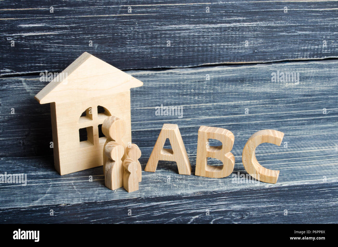 Wooden figures of children stand in a row from small to large near the ...