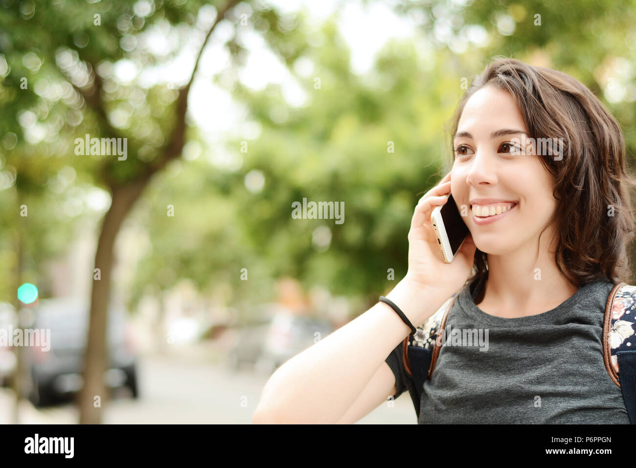 Portrait of young latin woman talking on her mobile phone. Outdoors ...