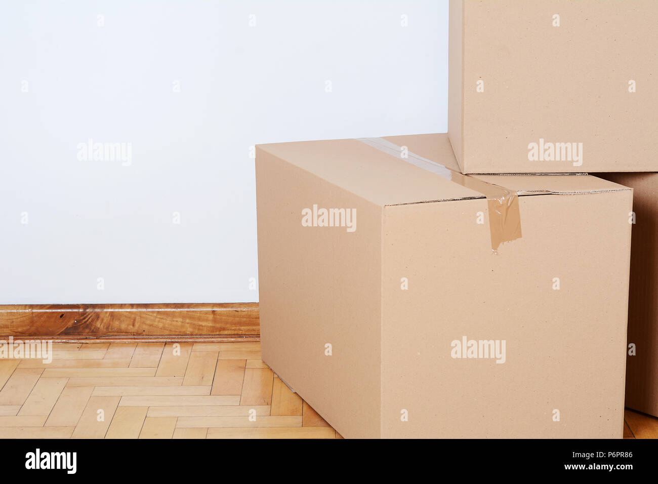 Stack of cardboard boxes in the empty room with copy space. Move ...