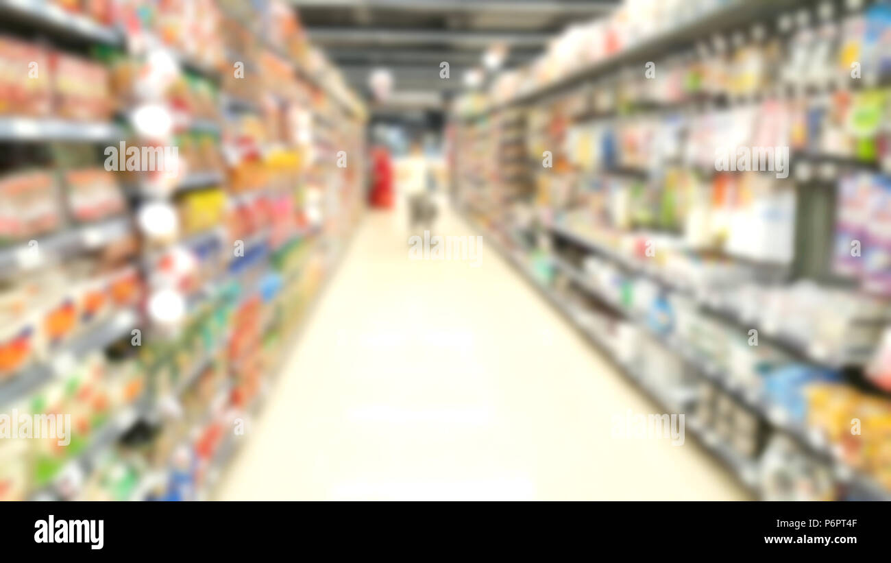 Abstract blur of aisle in supermarket with customers and department ...