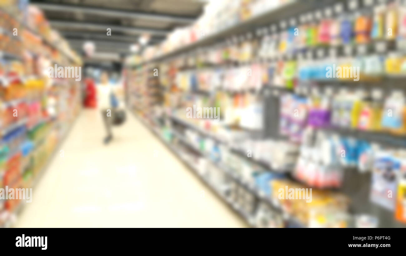 Abstract blur of aisle in supermarket with customers and department ...