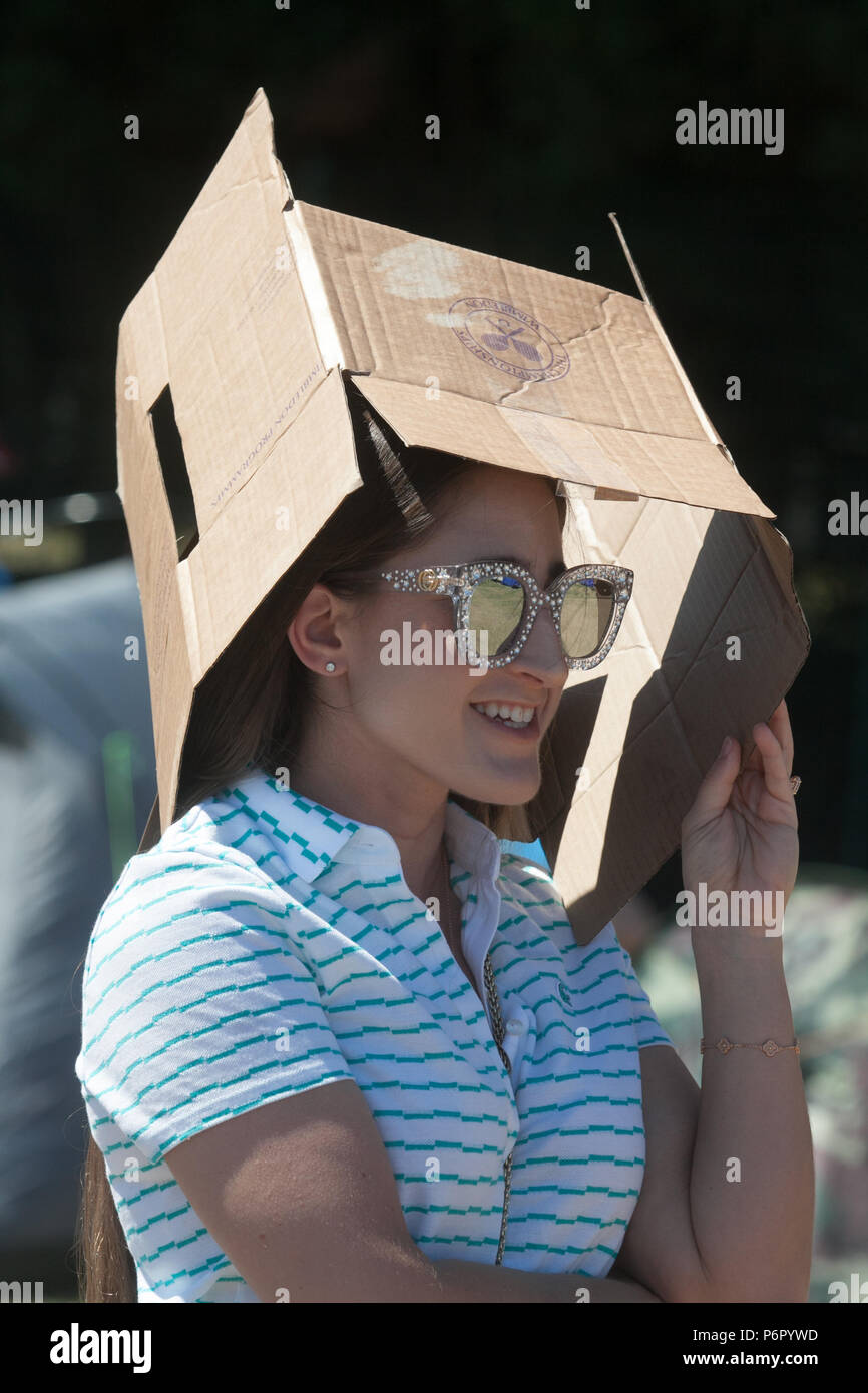 London UK. 2nd July 2018. A tennis fan shelters from the heat and the ...
