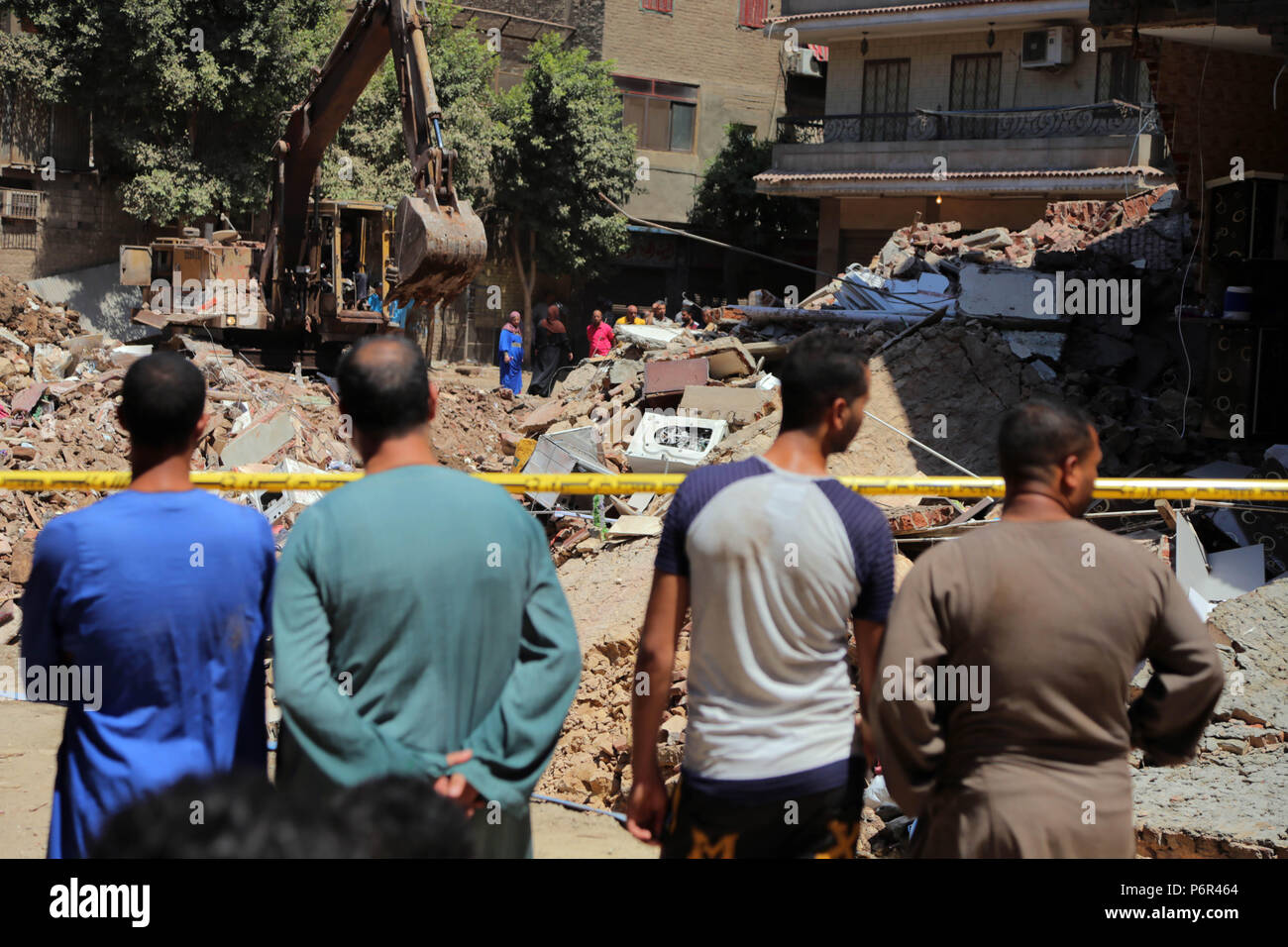 Cairo, Egypt. 2nd July, 2018. People are seen at the building collapse ...