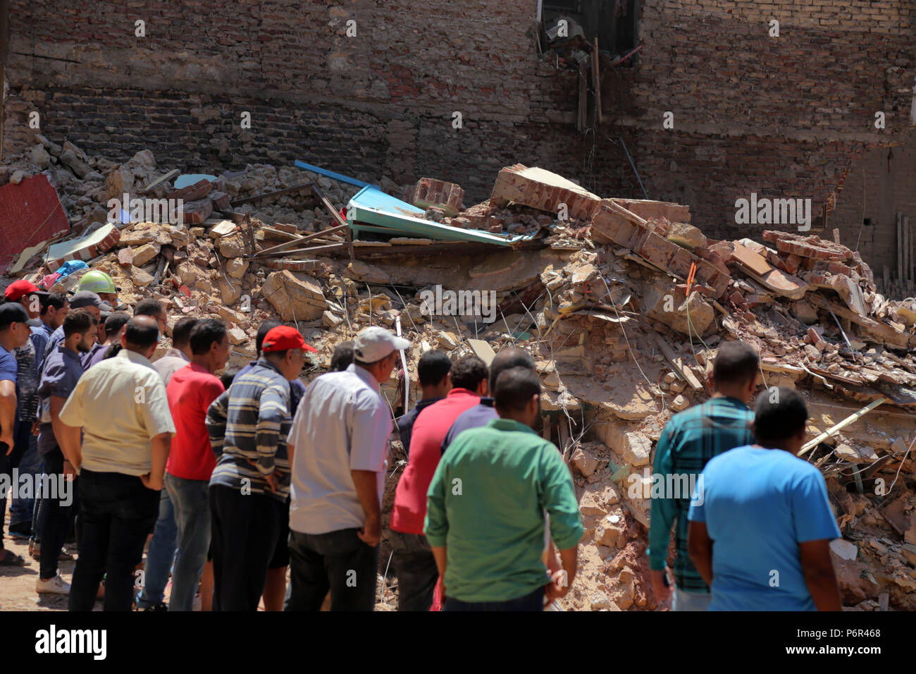 Cairo, Egypt. 2nd July, 2018. People are seen at the building collapse ...