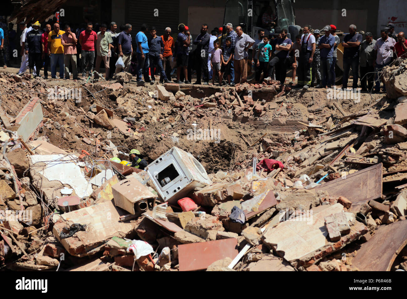 Cairo, Egypt. 2nd July, 2018. People are seen at the building collapse ...