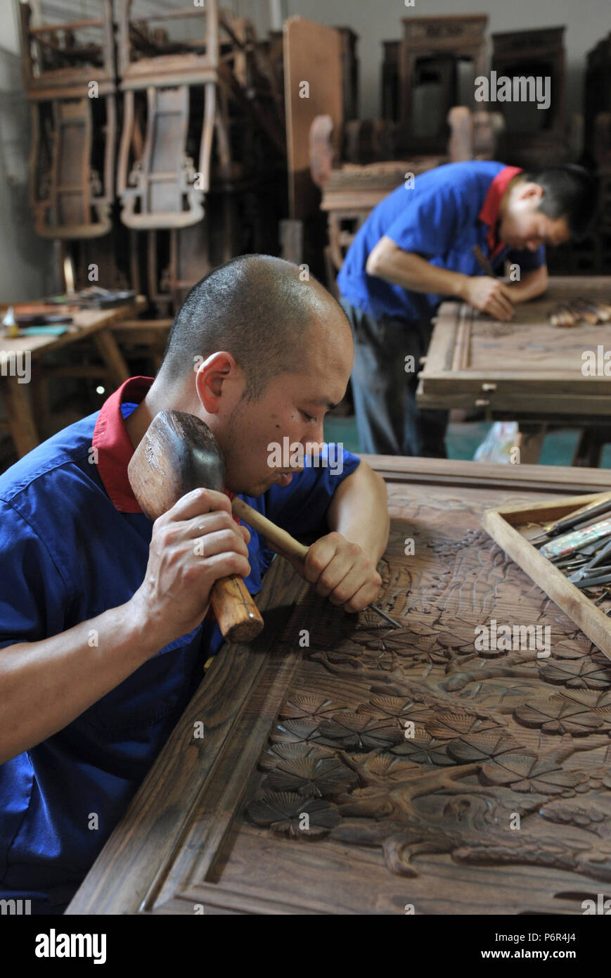 Dongyang, China's Zhejiang Province. 27th June, 2018. Workers carve on ...