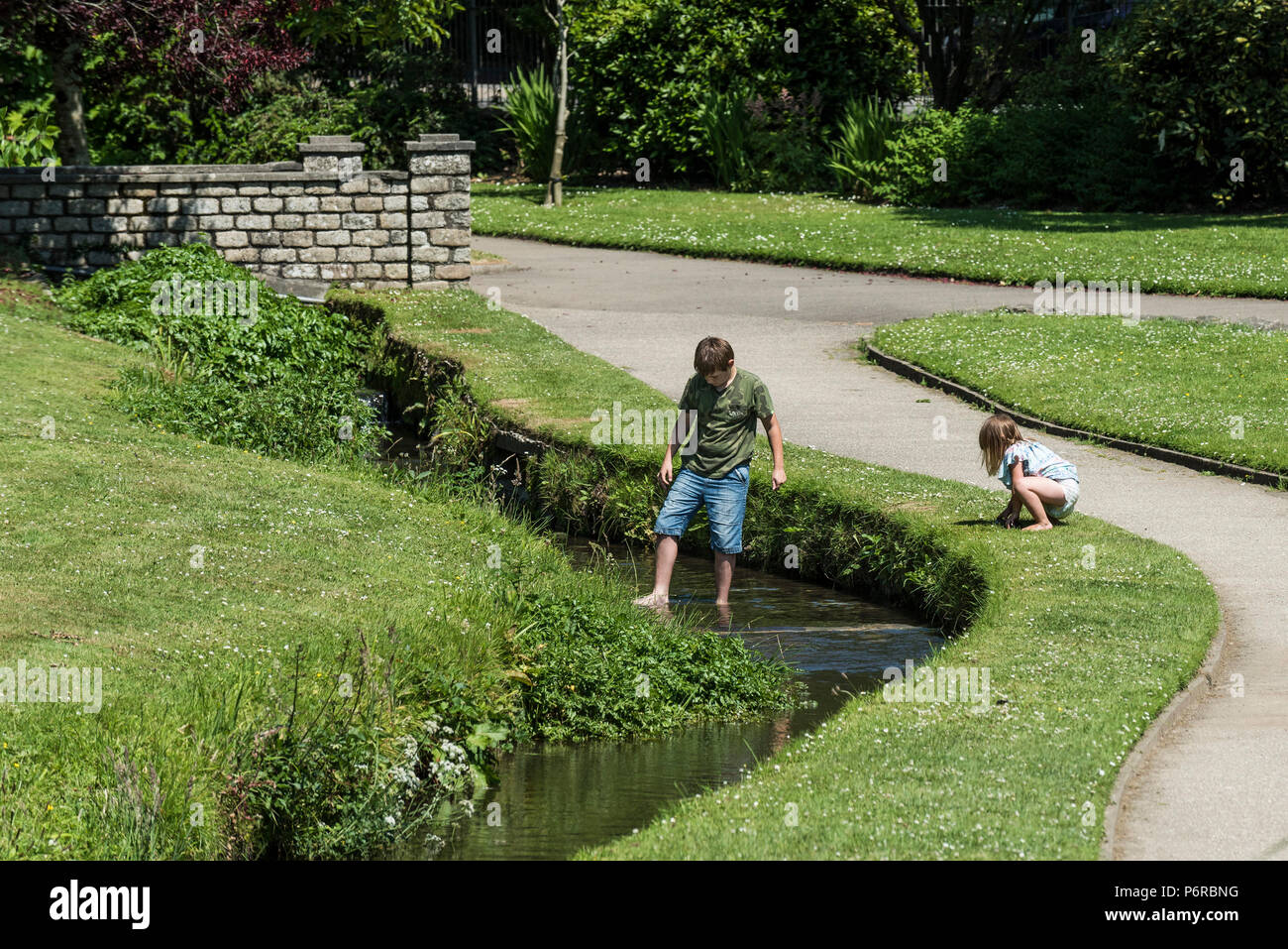 Young children playing in the stream flowing through Trenance Park in ...