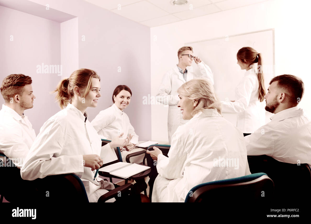 Happy cheerful positive smiling medical students communicating during ...