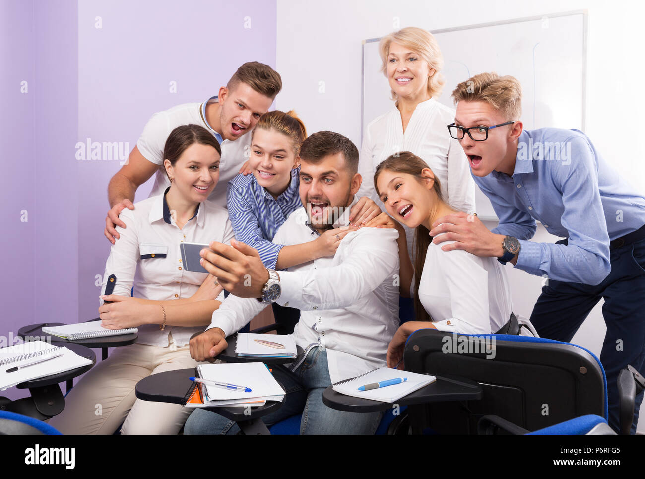 Group of happy adult students and female professor taking selfie in ...