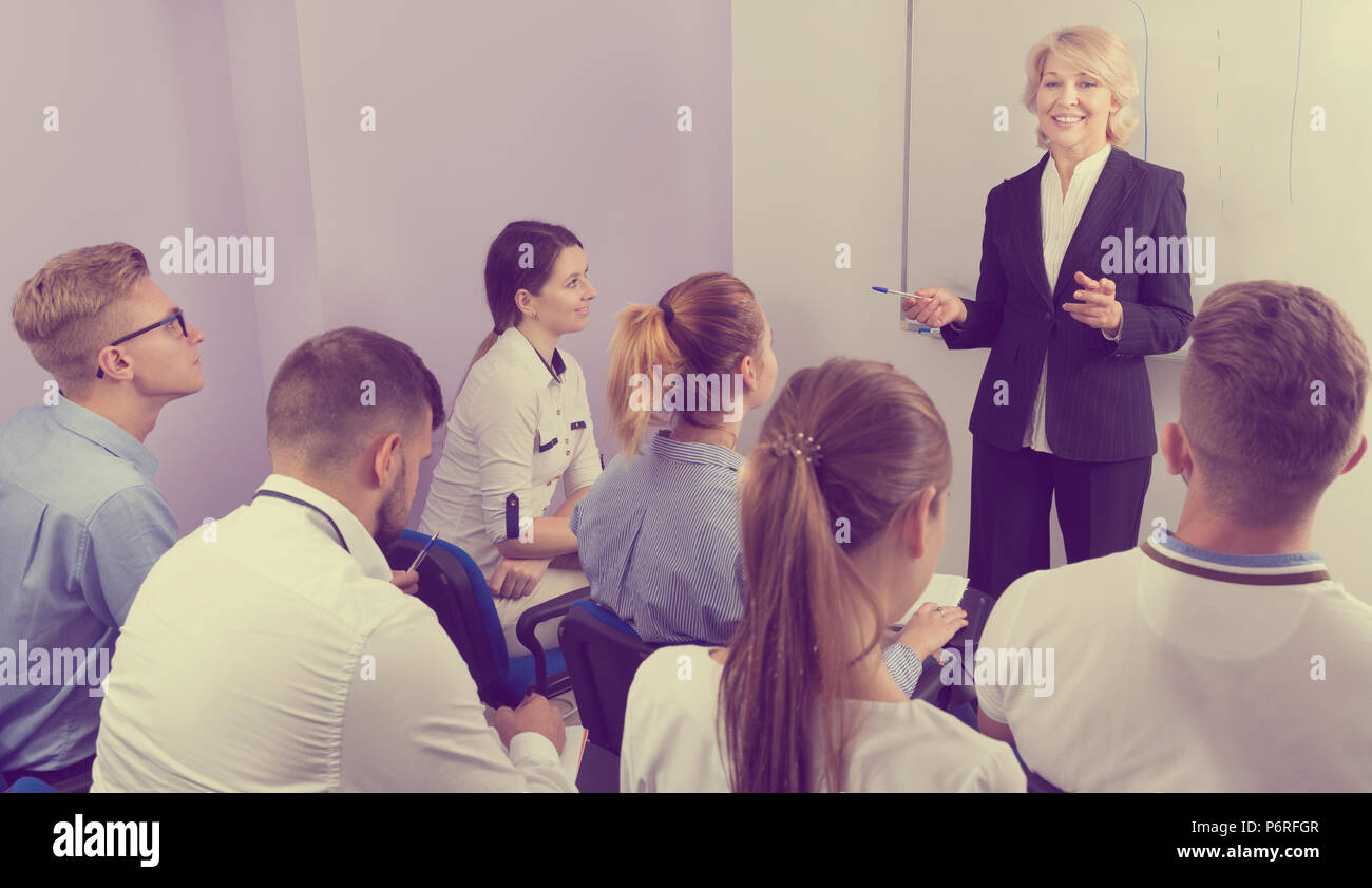 Elegant female teacher lecturing to students in auditorium Stock Photo ...