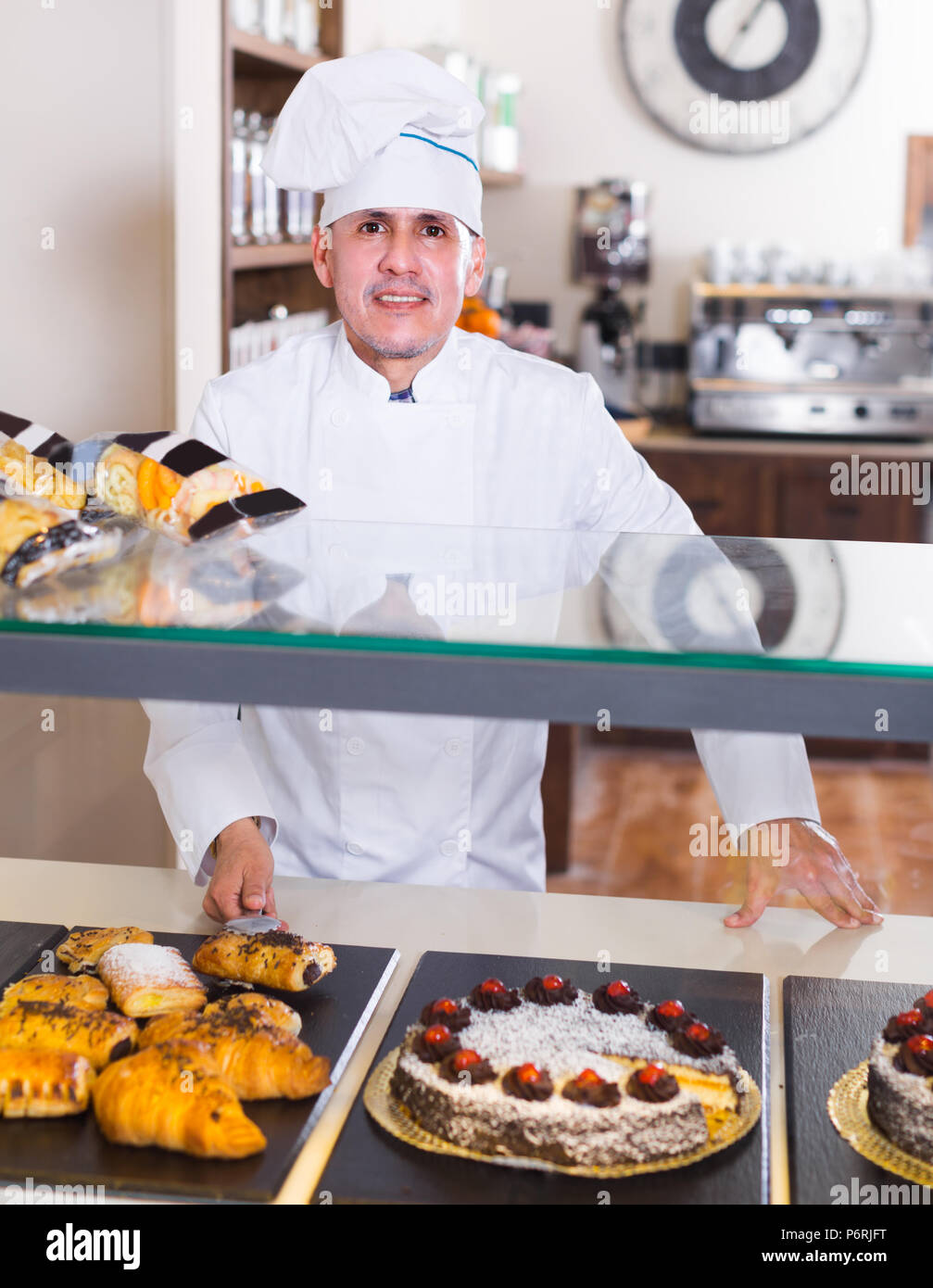 Baker man is offering tasty cakes, rolls and pies in bakery Stock Photo ...