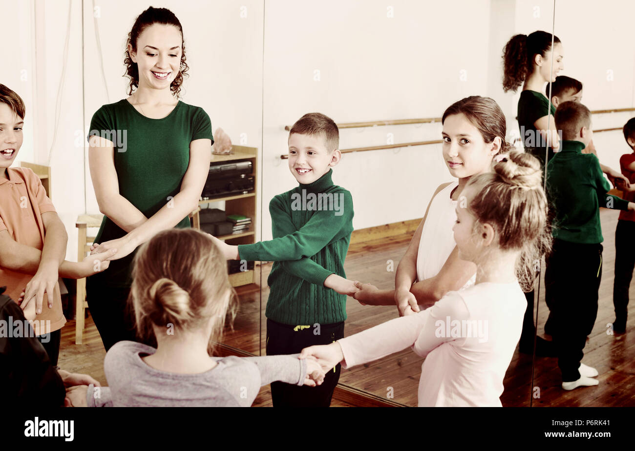 Cheerful positive children dancing folk dance in studio smiling and ...