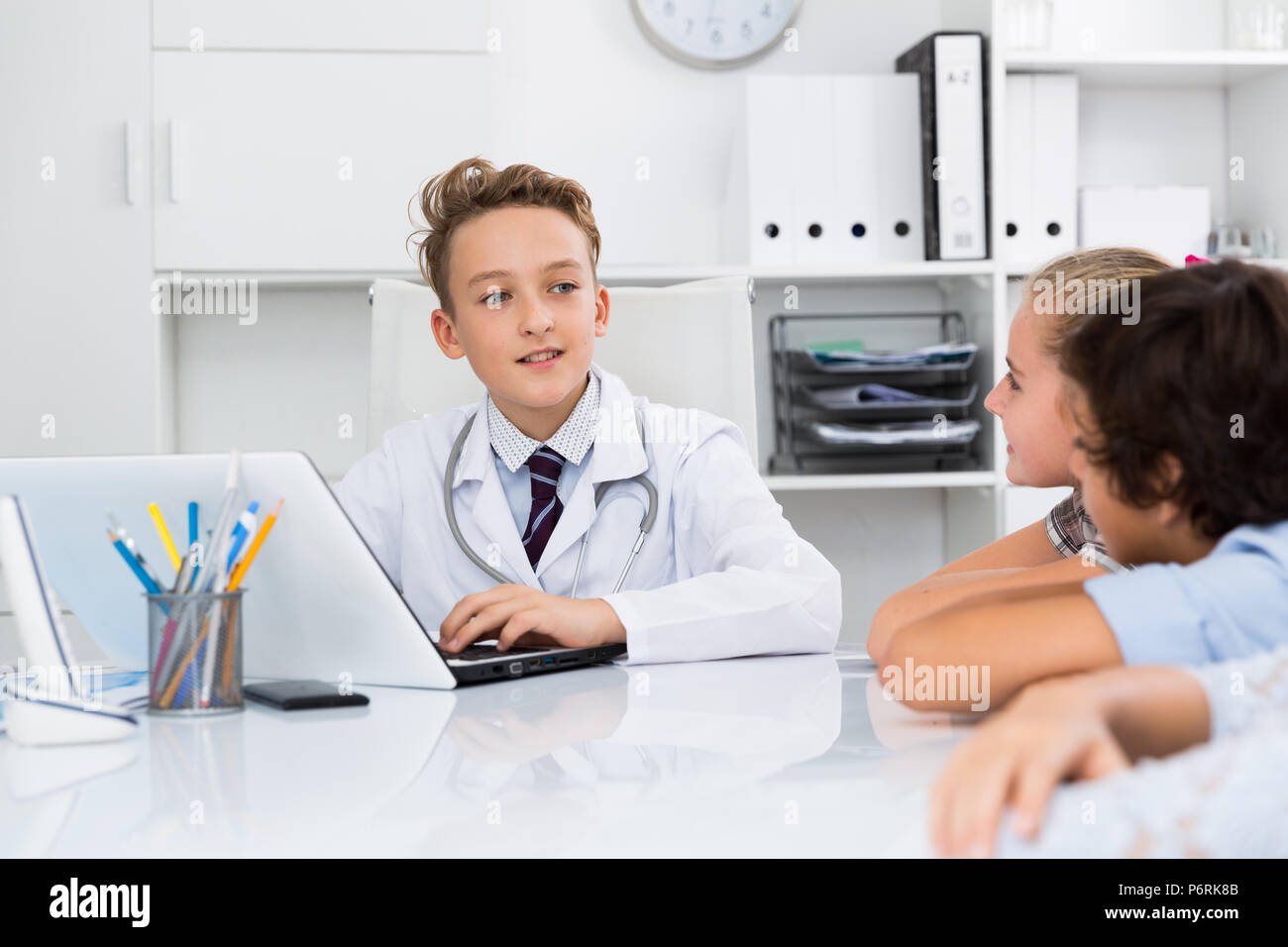 Medical brother boy in medical center with stethoscope with visitors ...