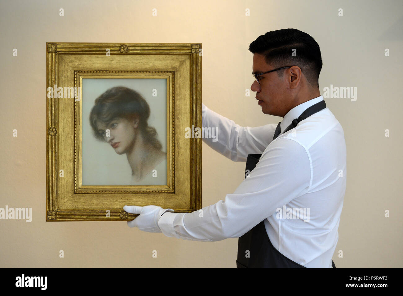 A gallery assistant holds Head study of Marie Spartali Stillman by ...