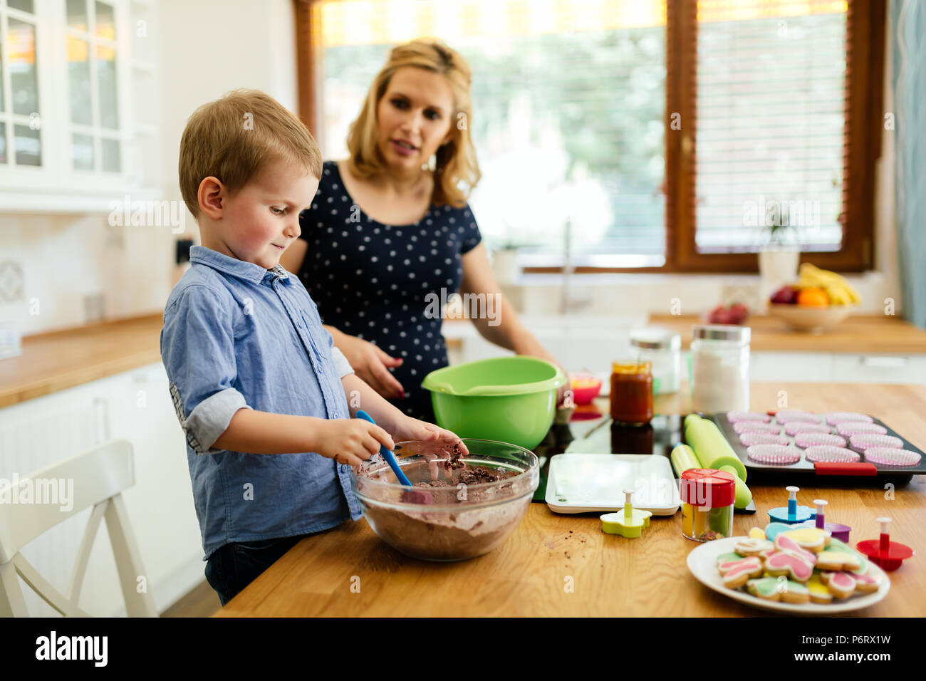 Smart cute child helping mother in kitchen Stock Photo - Alamy