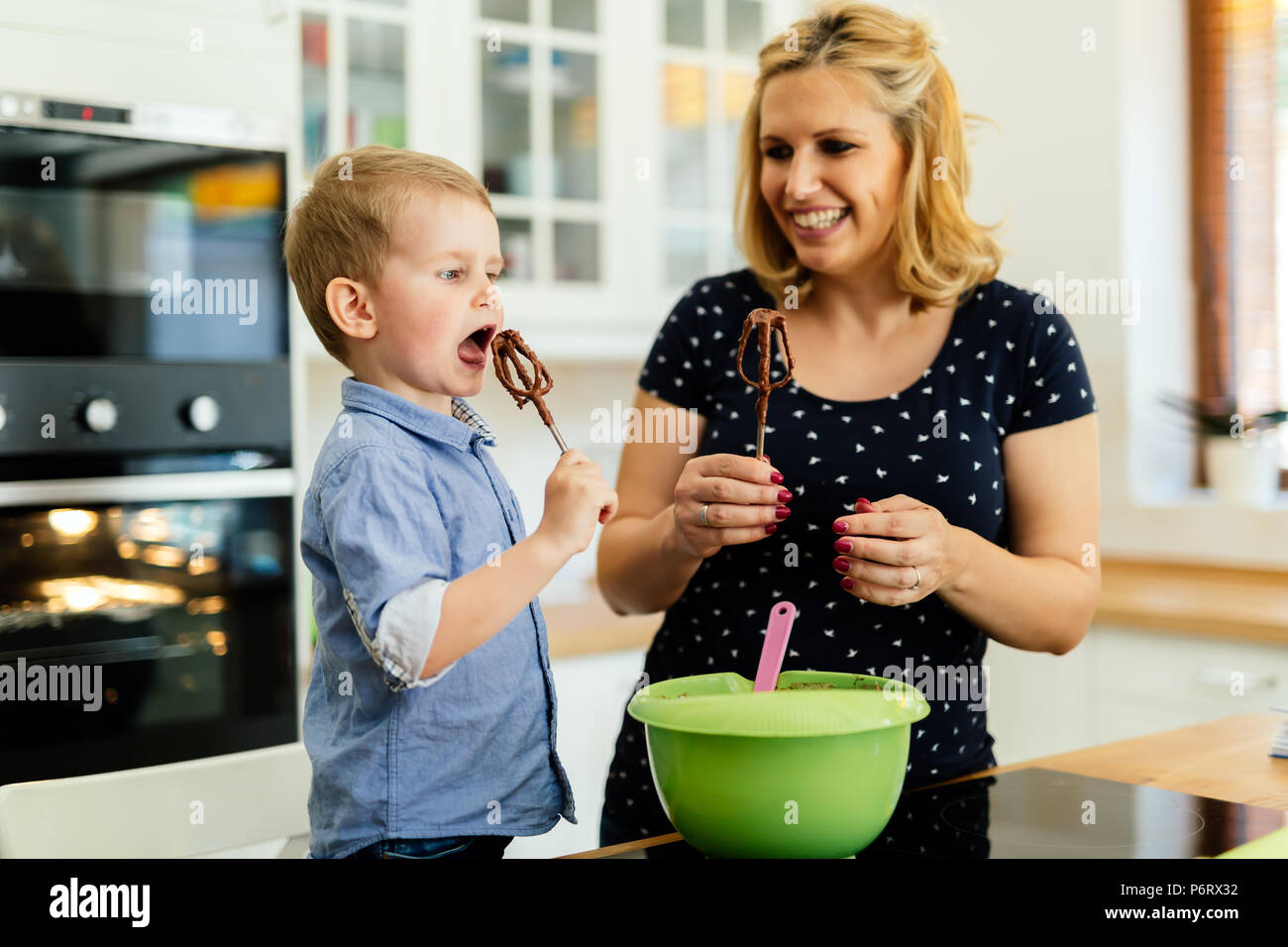 Smart cute child helping mother in kitchen Stock Photo - Alamy