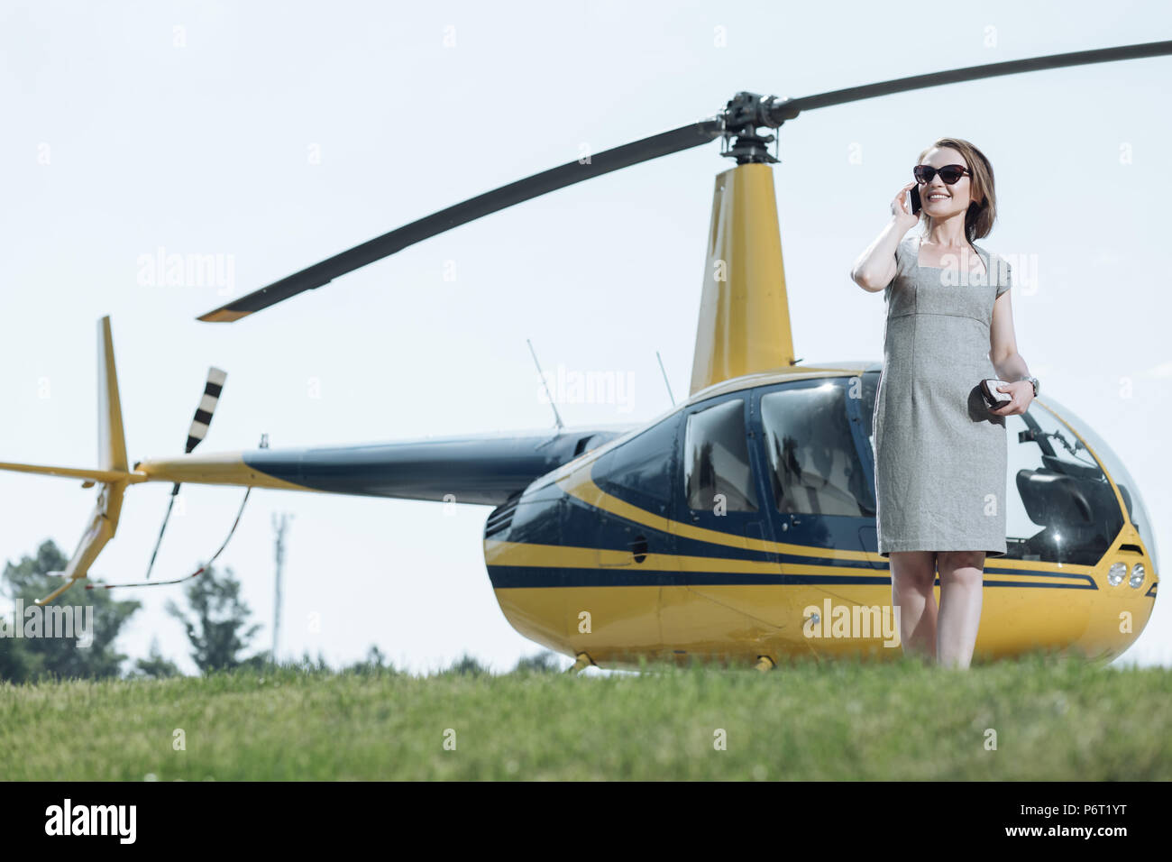 Beautiful young woman calling helicopter pilot Stock Photo - Alamy