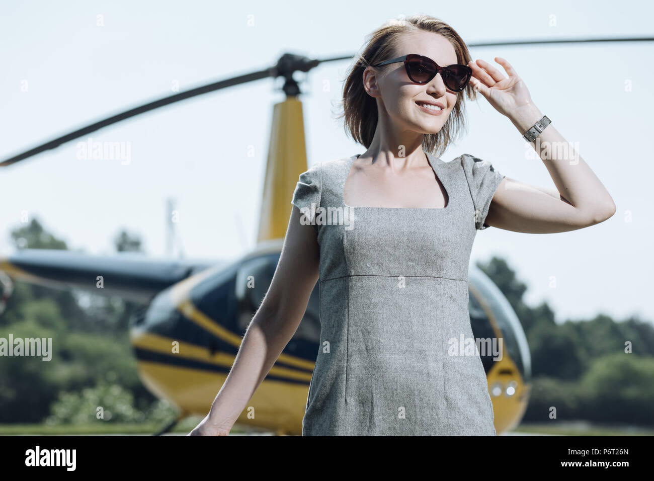 Pretty female executive looking at helipad Stock Photo - Alamy