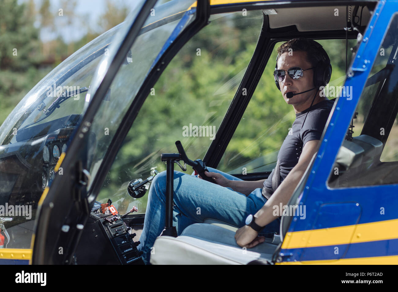 Handsome young pilot posing inside helicopter Stock Photo - Alamy