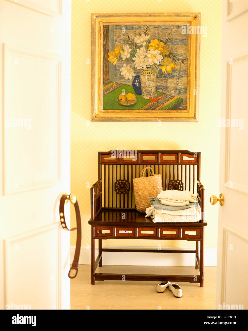 Floral painting on wall above antique settle in pale yellow country ...