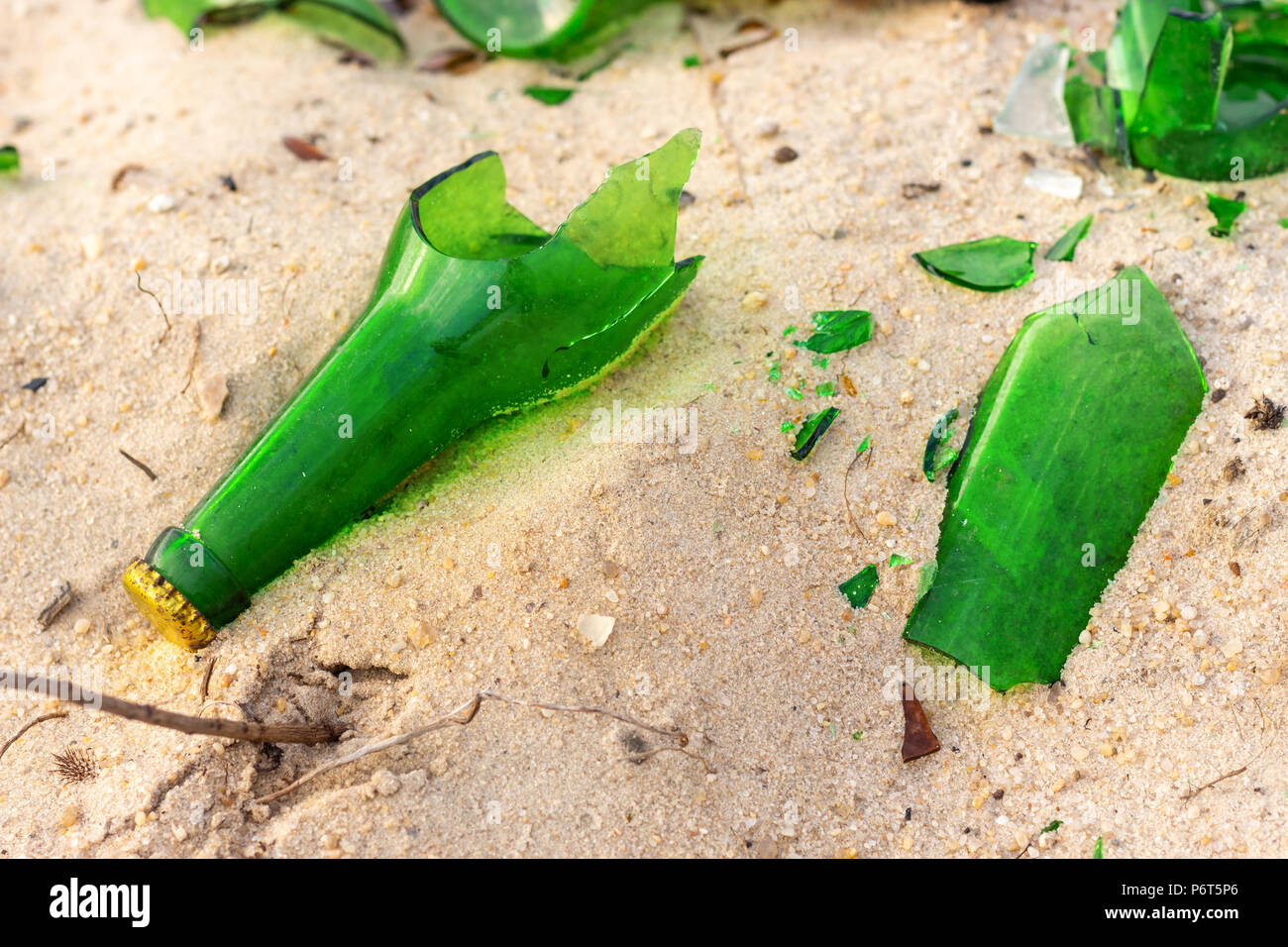 Broken beer glass bottles on a sand Stock Photo - Alamy