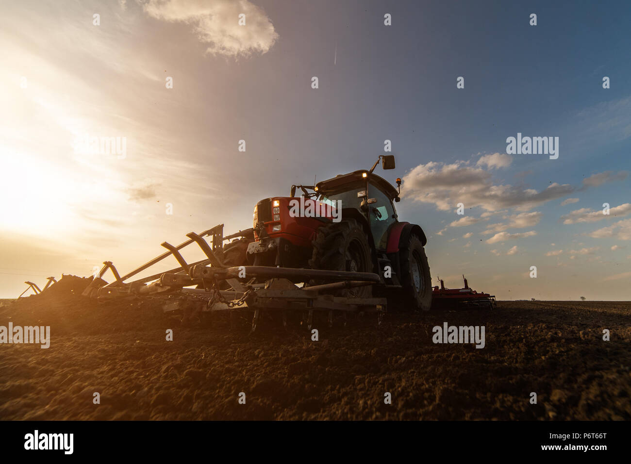 Tractor plowing fields -preparing land for sowing Stock Photo - Alamy