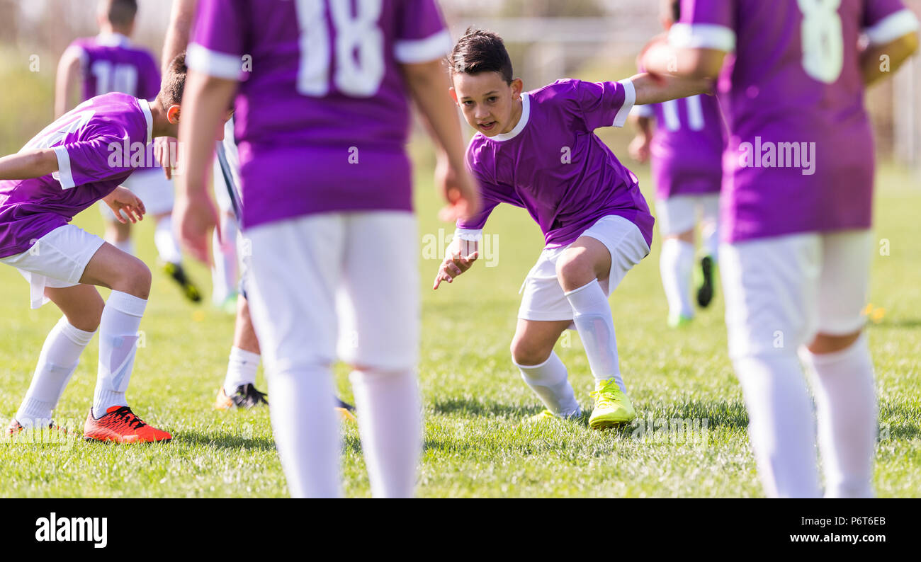 Boy kicking football on the sports field during soccer match Stock ...