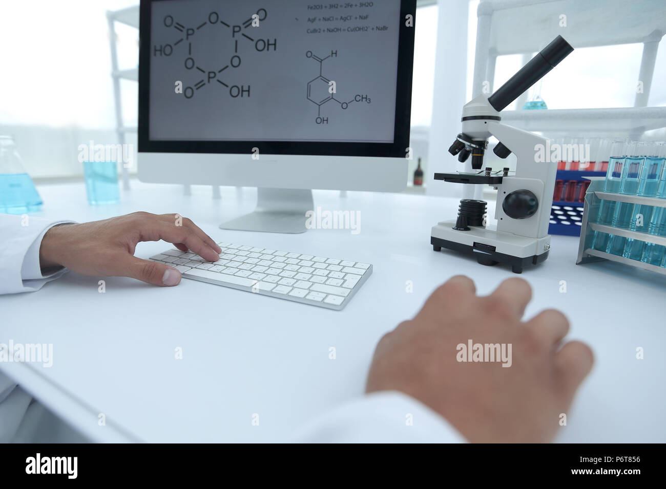 A scientist uses a computer and a microscope Stock Photo - Alamy