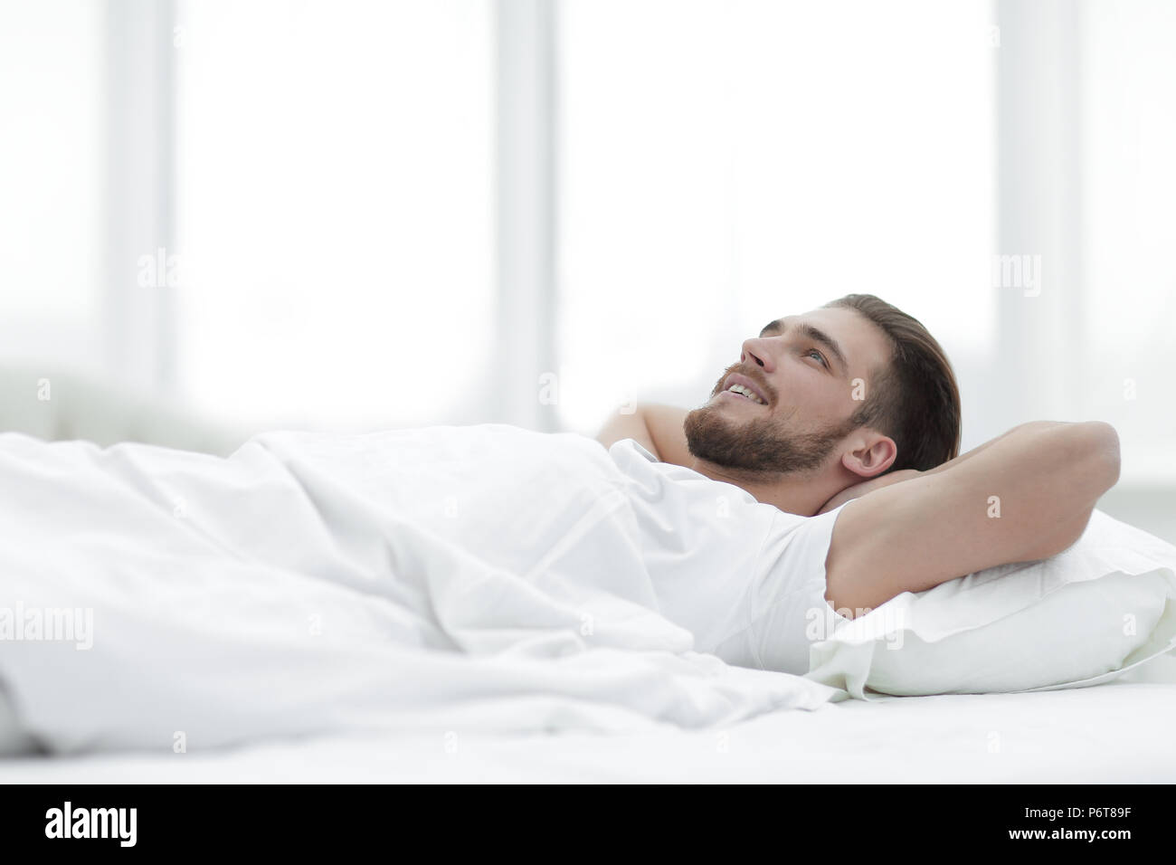 tired man resting on a comfortable bed Stock Photo - Alamy