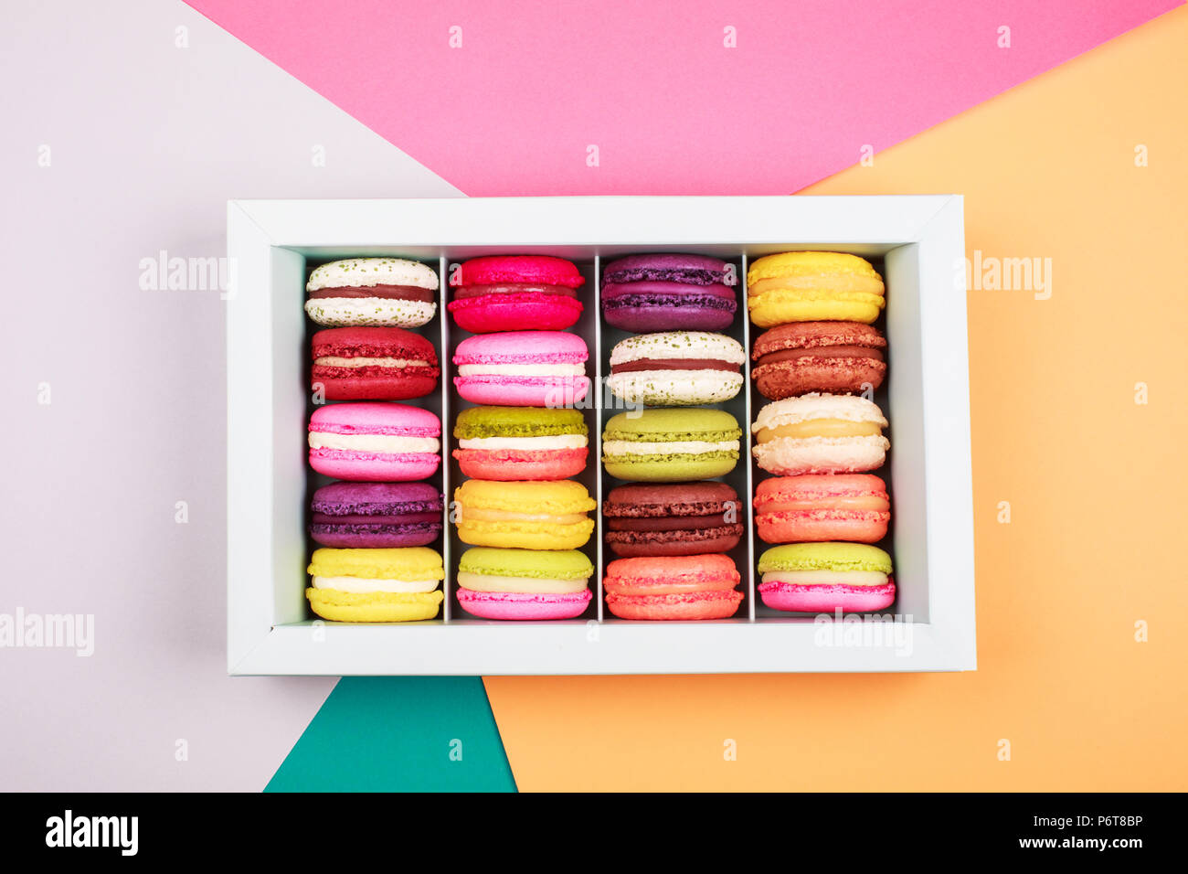 Box of colorful macarons on trendy colorful background divided in fur ...